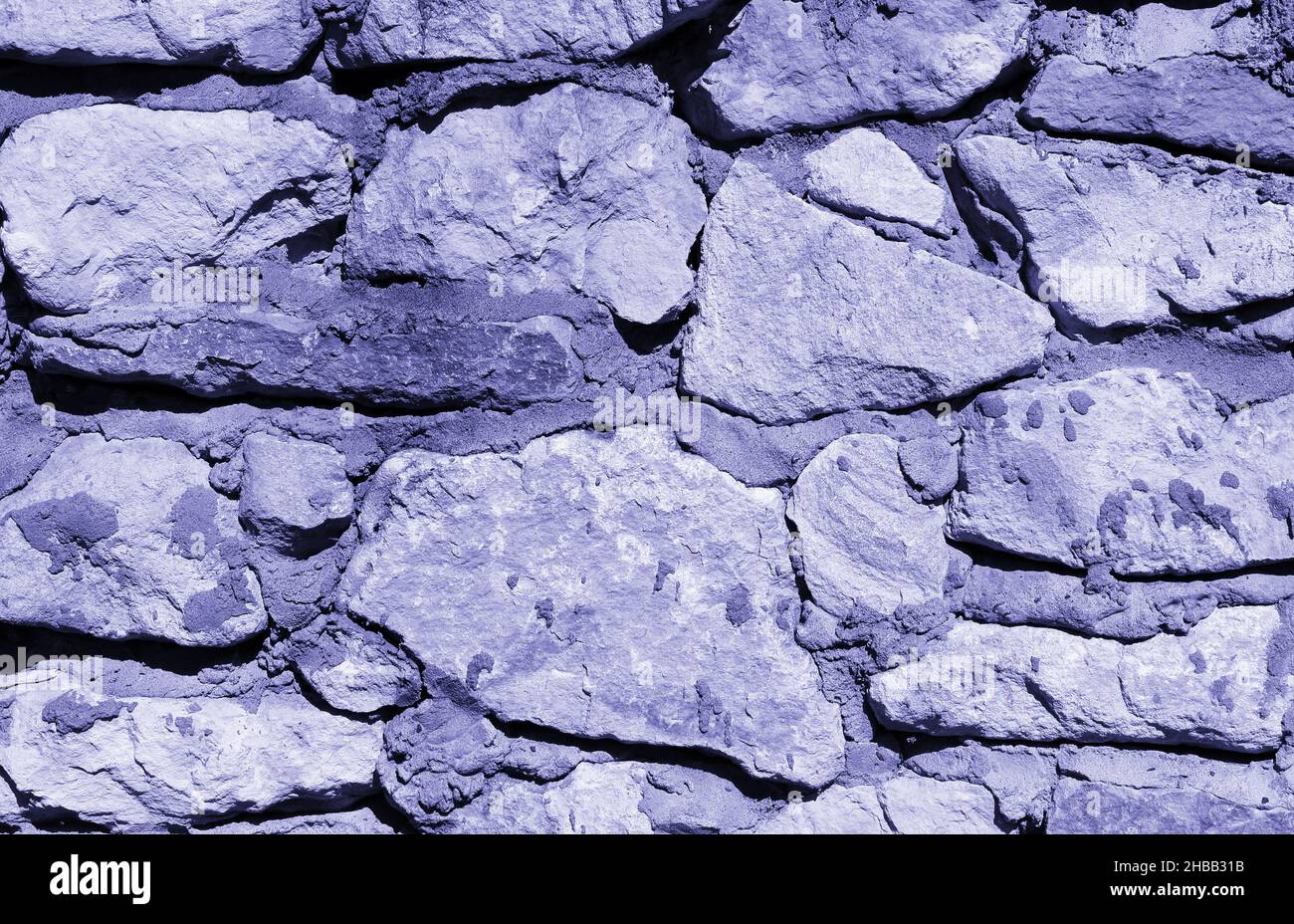 Close-up textured surface of rough stone blocks wall. Very peri color ...