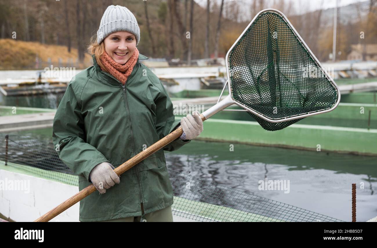 Woman with landing net on fish farm Stock Photo - Alamy