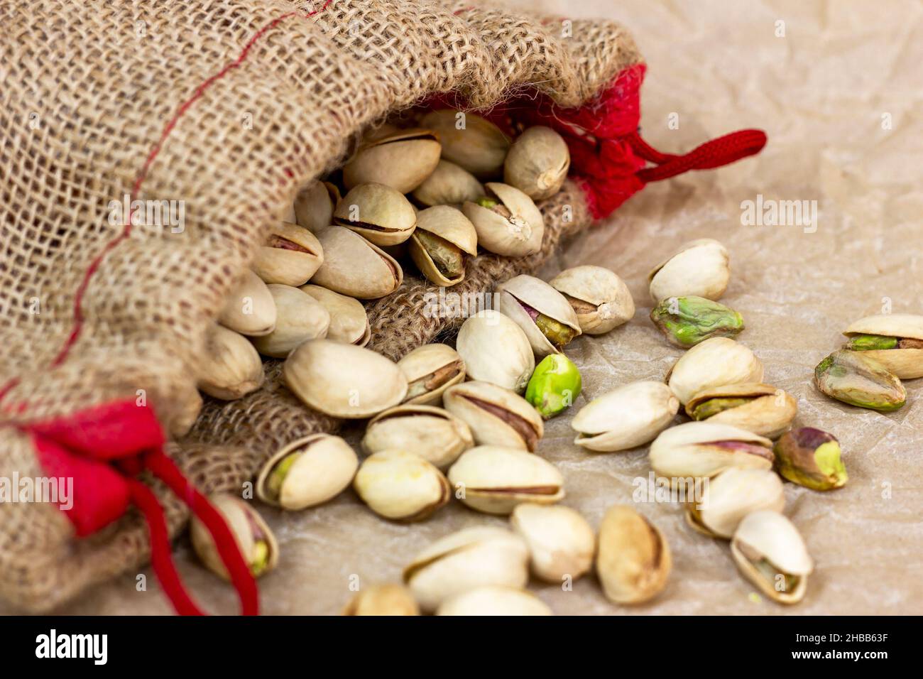 Roasted salted pistachio nuts in nutshell in the textile bag on light background Stock Photo - Alamy
