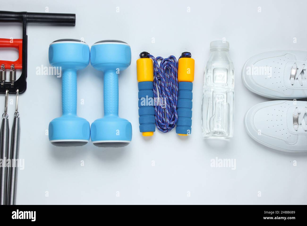 Flat lay style fitness concept. Dumbbells, sneakers, jump rope, bottle ...