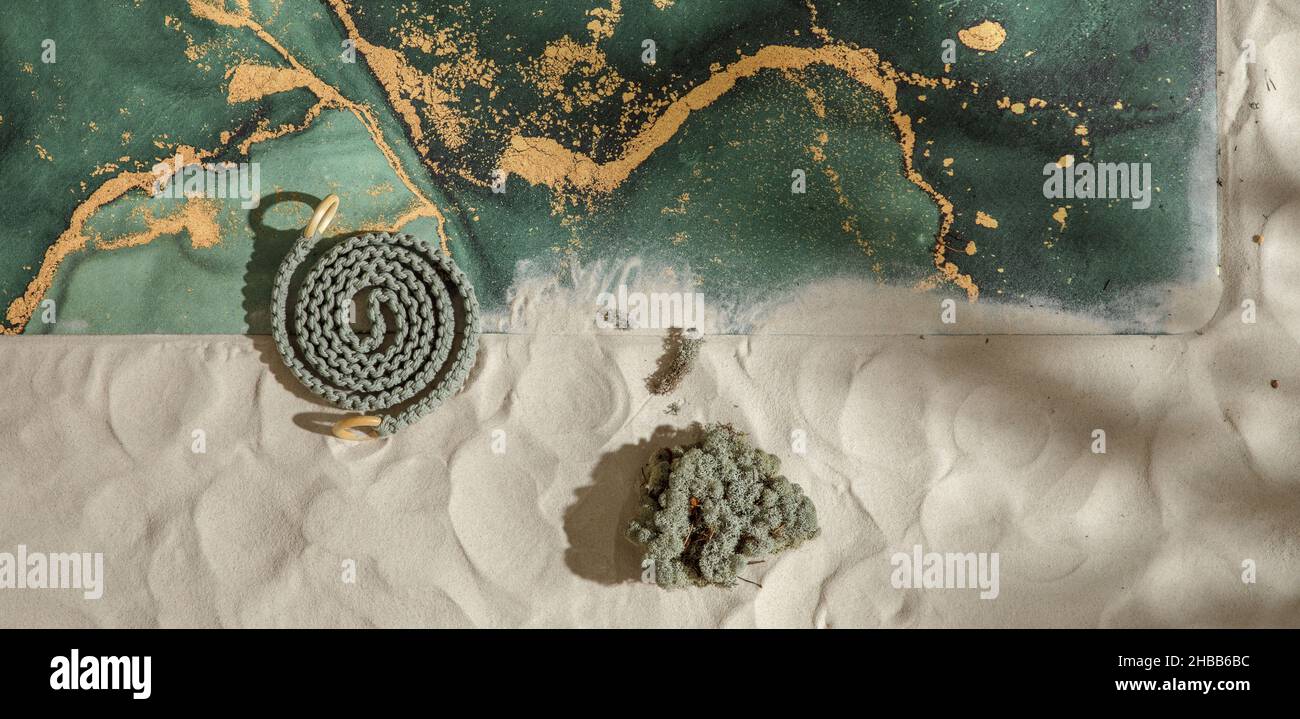 Unrolled moss green yoga mat, rope for stretching and dried moss on ...