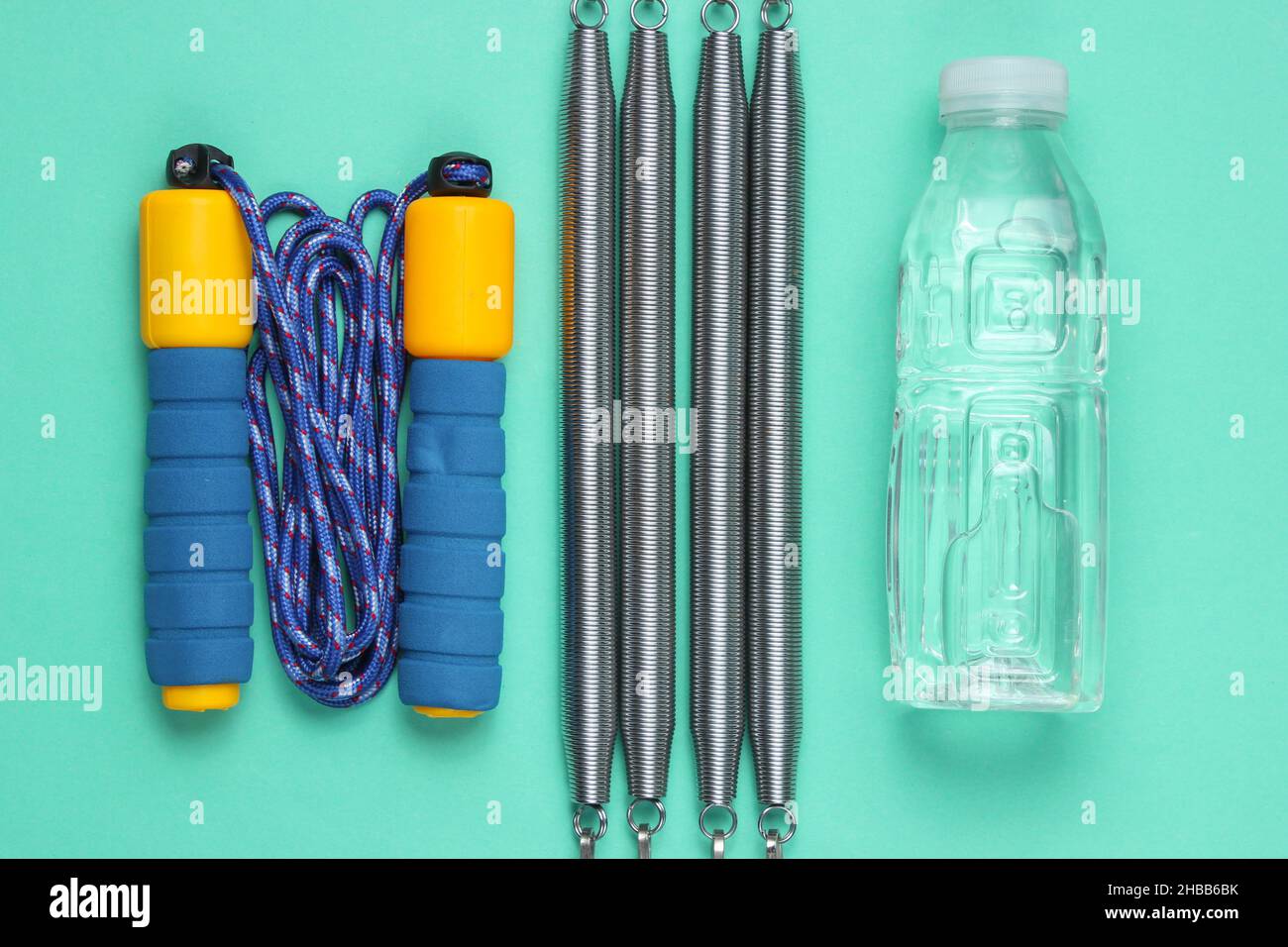 Flat lay style fitness concept. Jump rope, bottle of water, expander ...