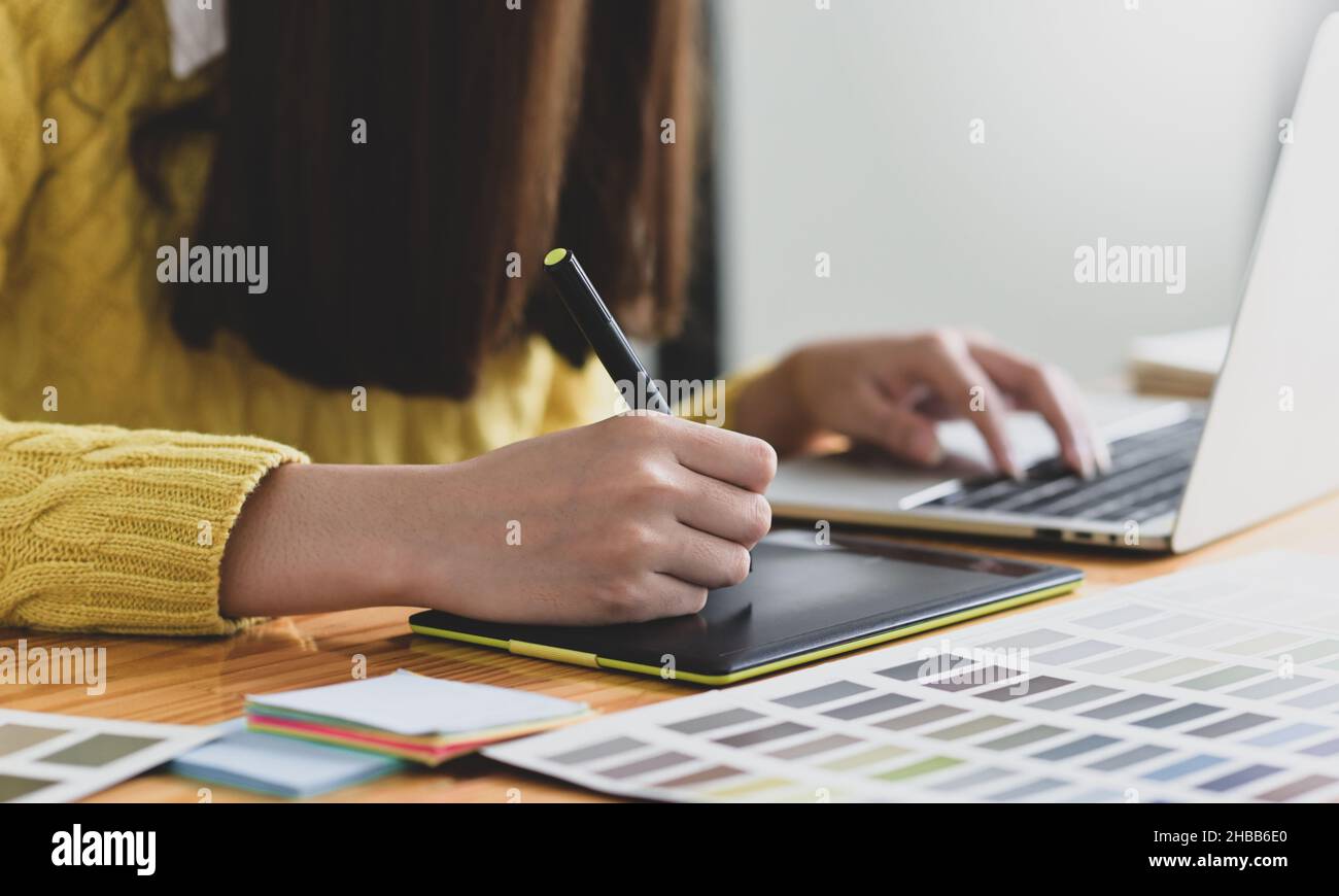 female designer sketching on a digital graphic tablet, A woman writing ...