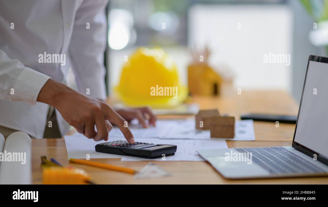 Young engineer is using a calculator to calculate house plans Stock ...
