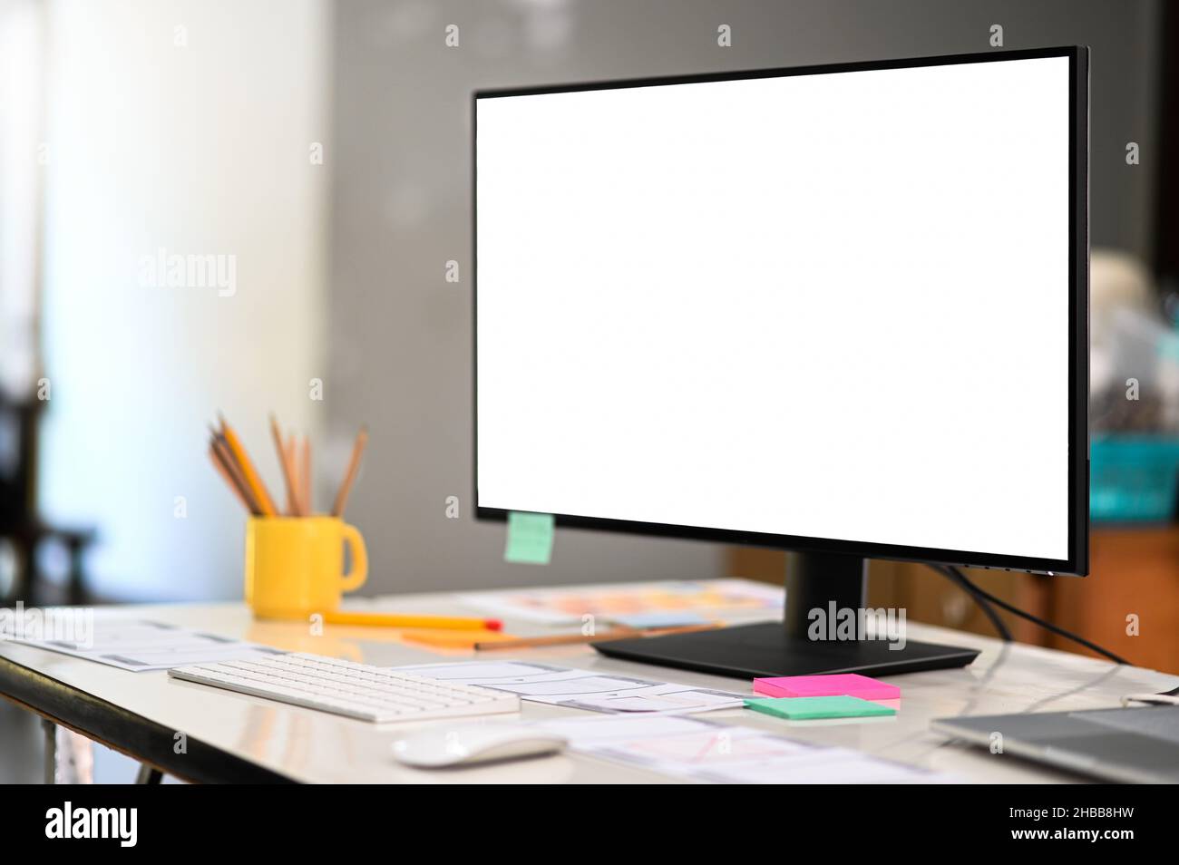 Mockup computer big blank screen on a professional designer desk in a ...