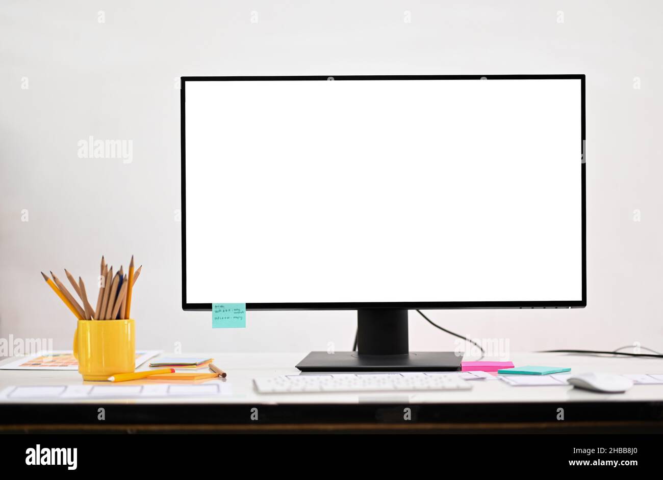 Mockup computer big blank screen on a professional designer desk in a ...