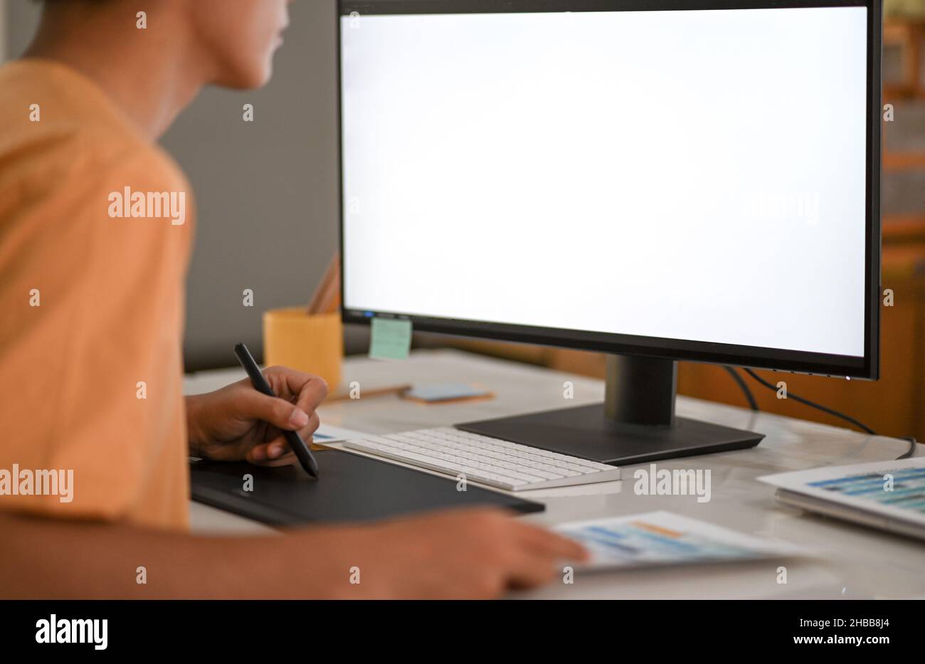 Graphic designer working on digital board with mockup computer monitor ...