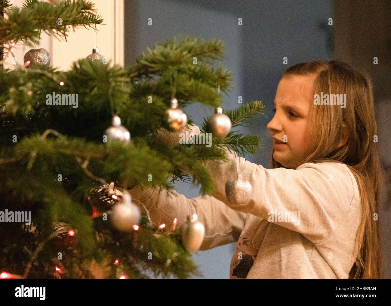 A girl dressing a Christmas tree Stock Photo - Alamy