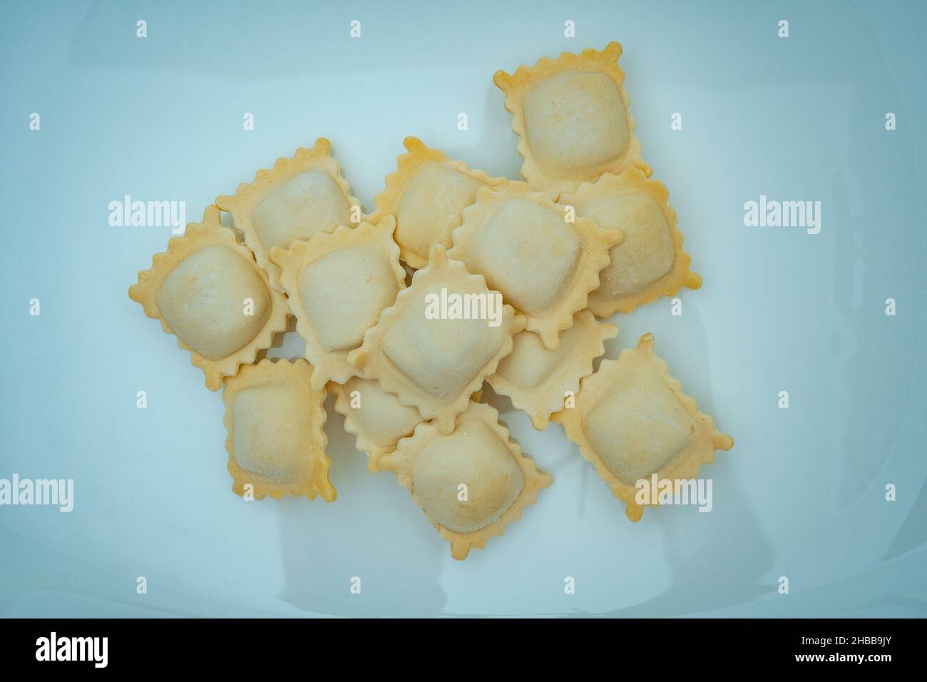 Ravioli pasta squares on a light blue background Stock Photo - Alamy