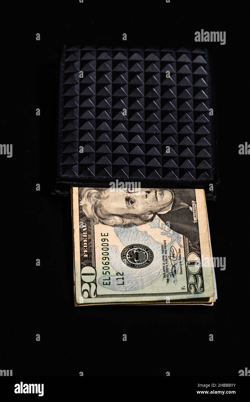 Closeup shot of American banknotes in a black wallet isolated a dark ...