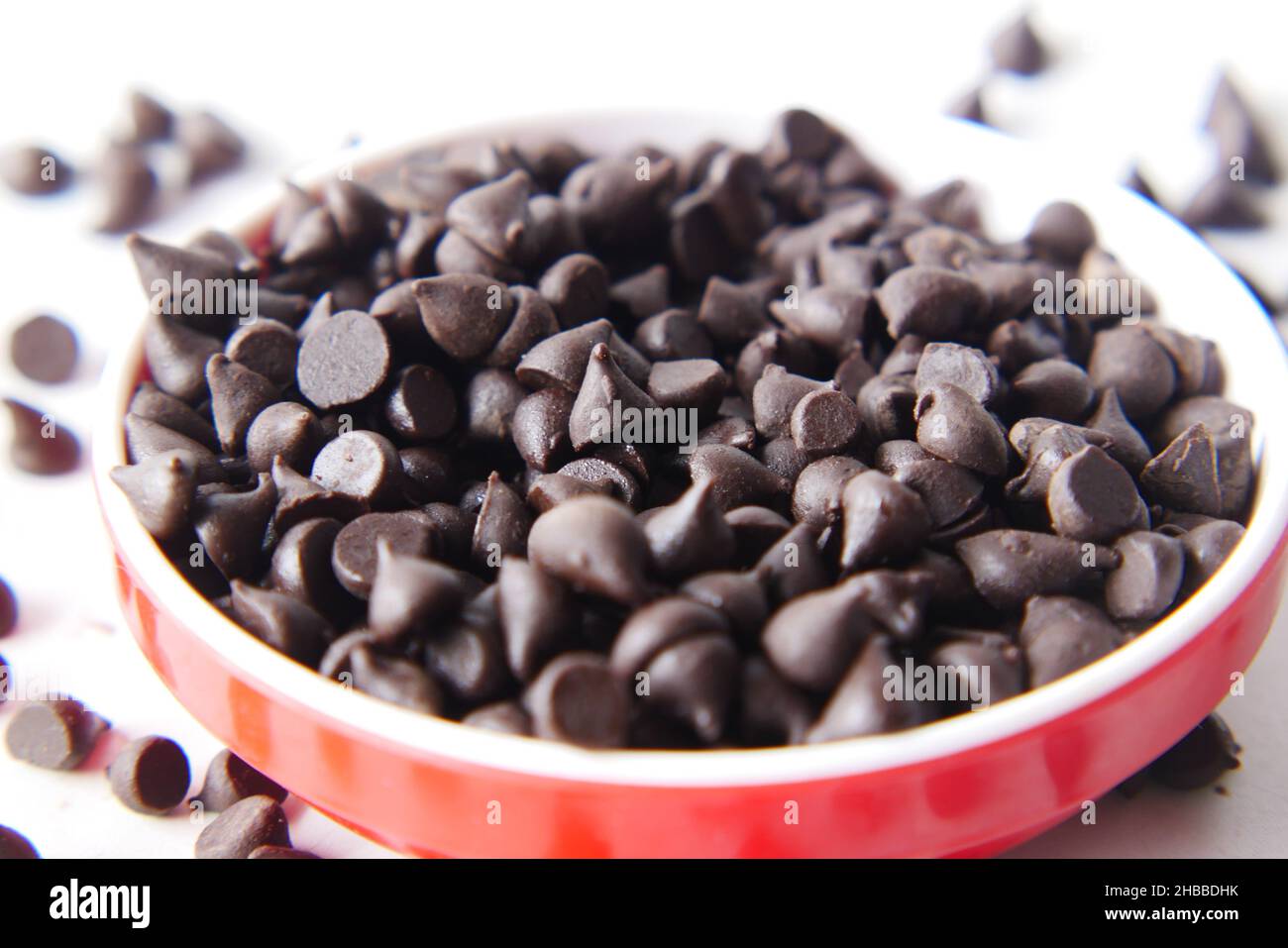 Chocolate chips spilling from a plastic packet Stock Photo - Alamy