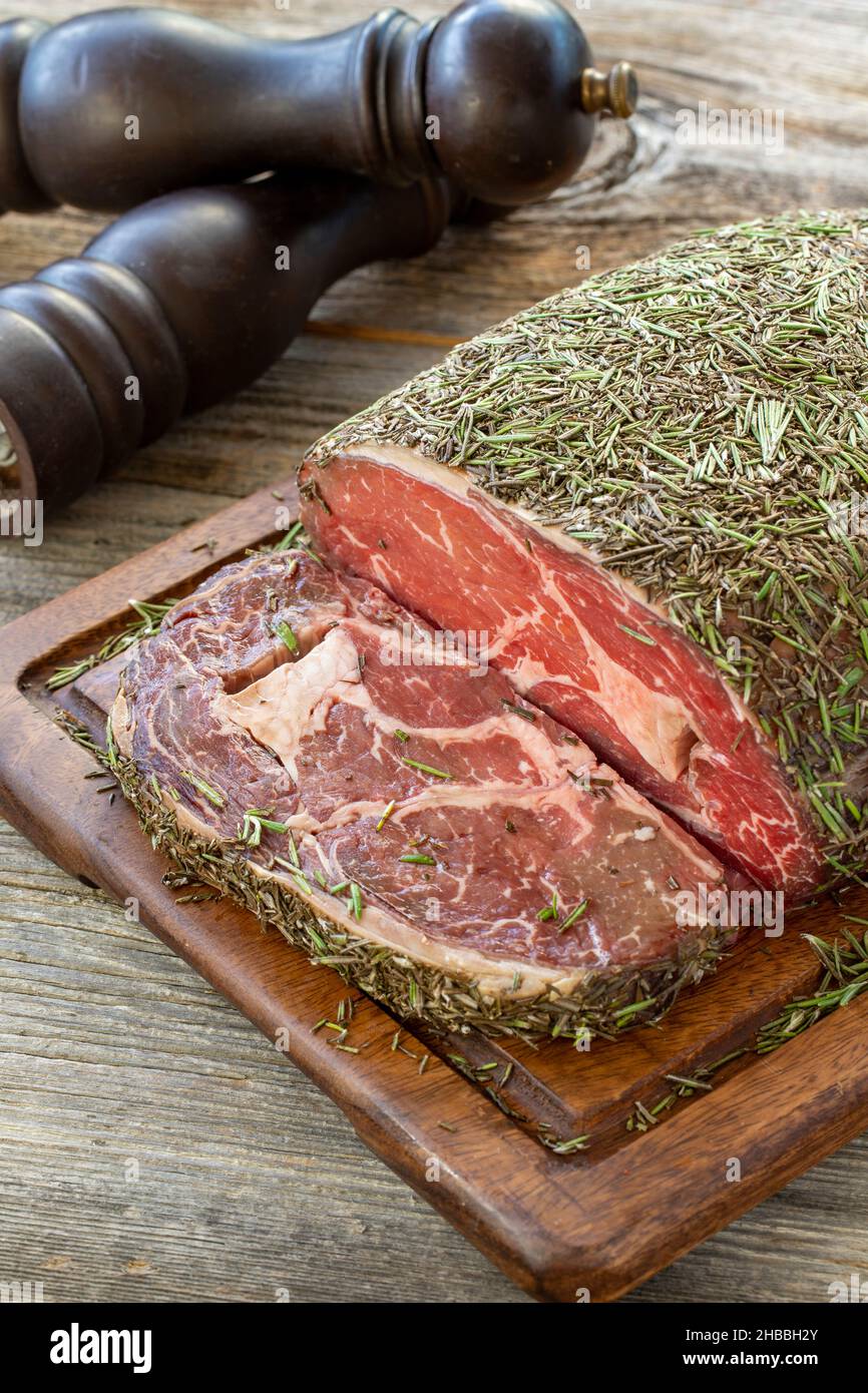 raw ribeye on wood background. Close-up of marinated beef ribeye with ...