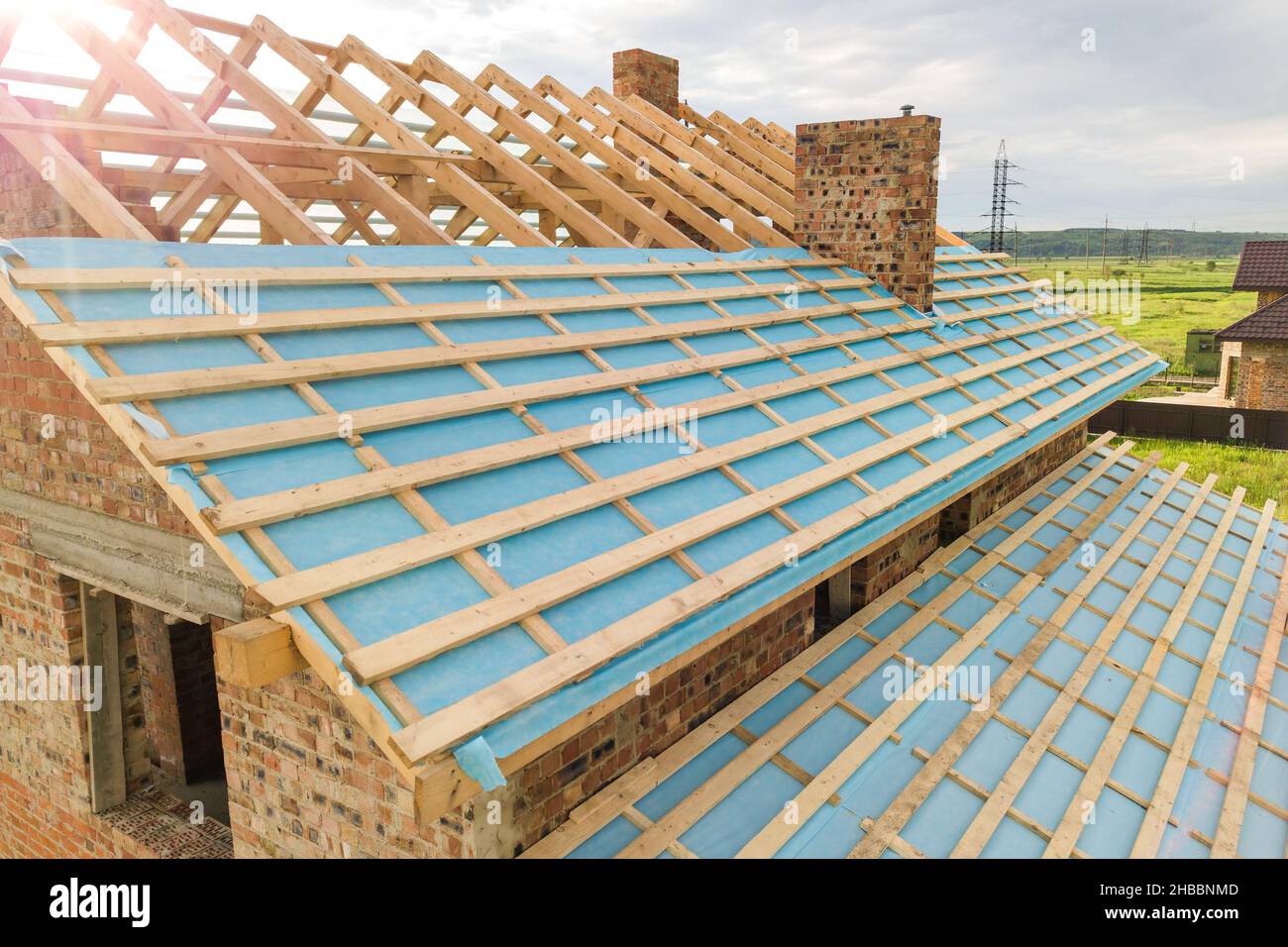 Aerial view of a brick house with wooden roof frame under construction ...