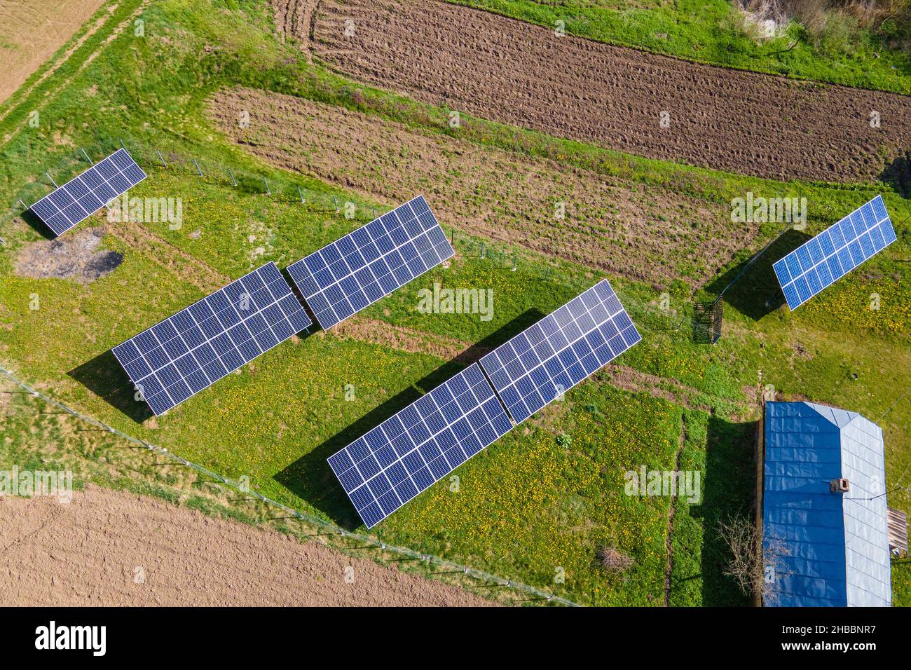 Aerial view of blue photovoltaic solar panels mounted on backyard ...