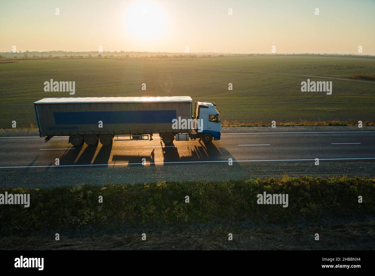 Aerial view of blurred fast moving semi-truck with cargo trailer ...