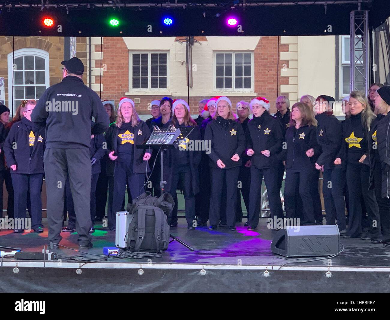 Market Square Northampton UK Rock Choir sing songs singing hat hats ...
