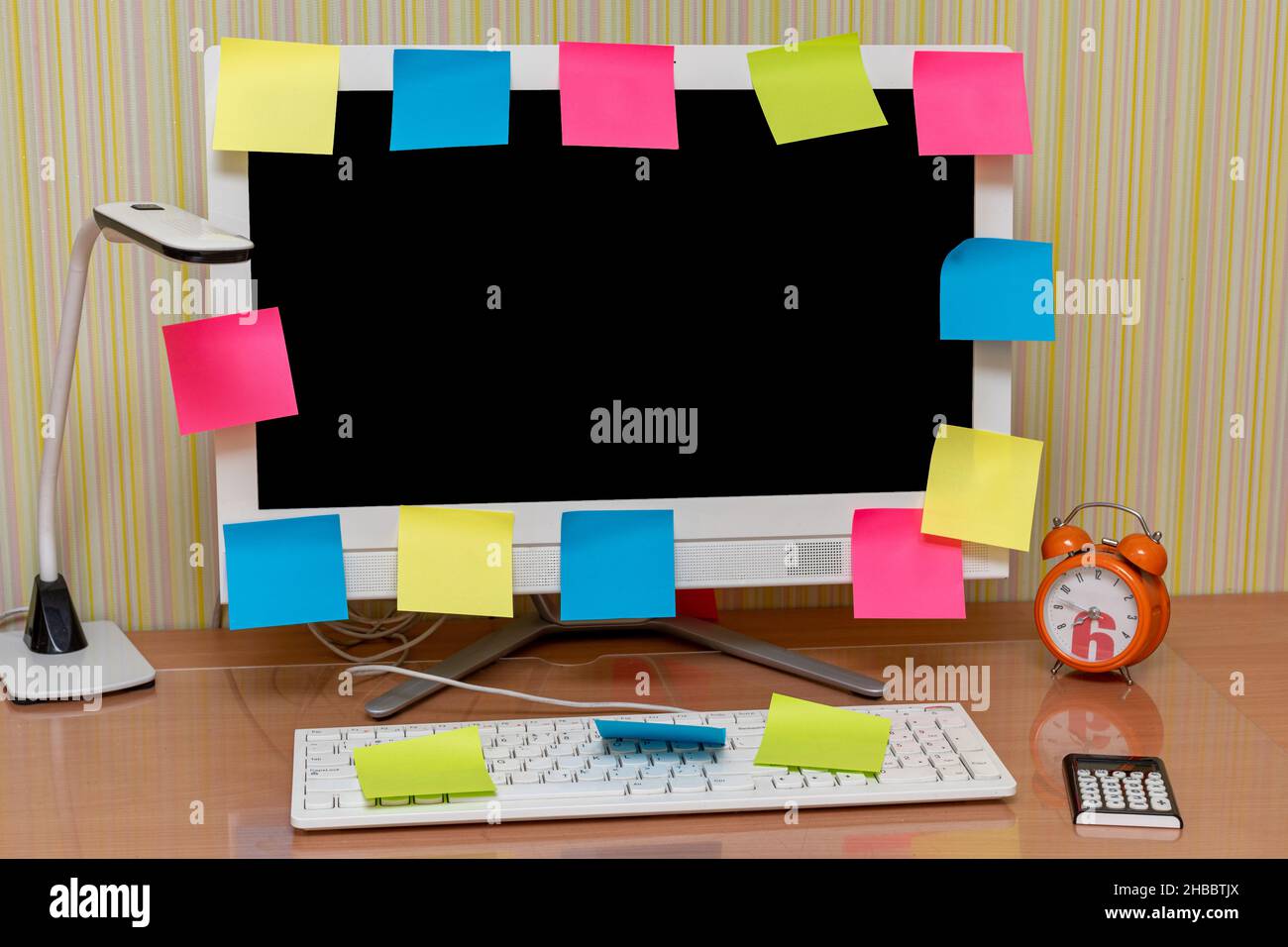 Workplace. On the monitor, multicolored blank stickers for planning ...