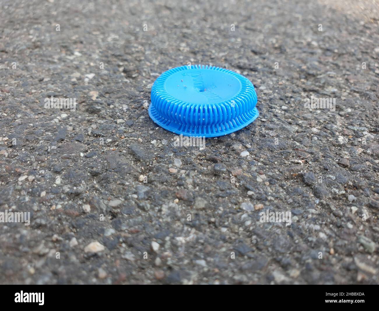 Blue, plastic bottle cap on the asphalt Stock Photo - Alamy