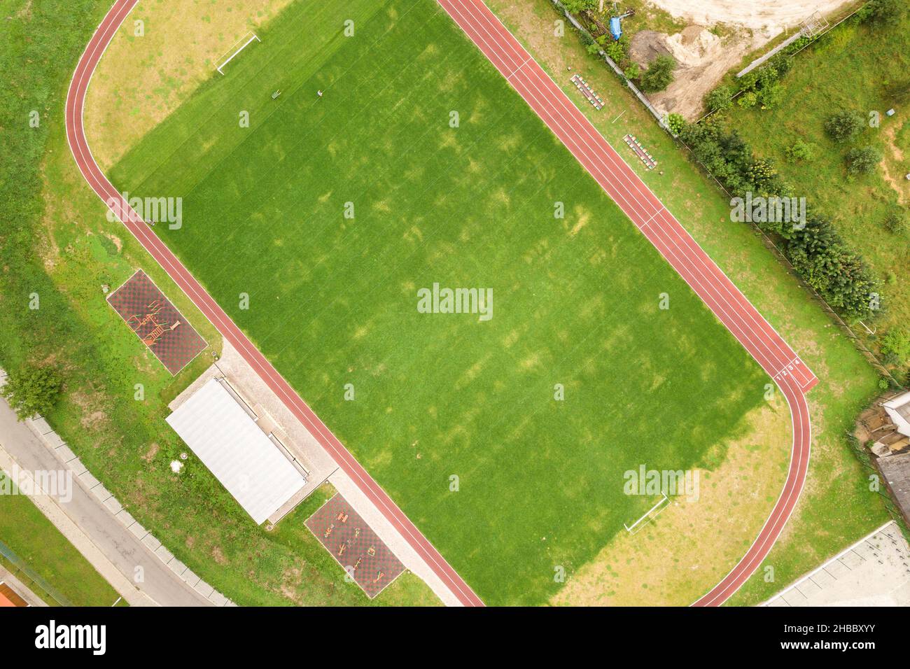 Aerial view of sports stadium with red running tracks and green grass ...