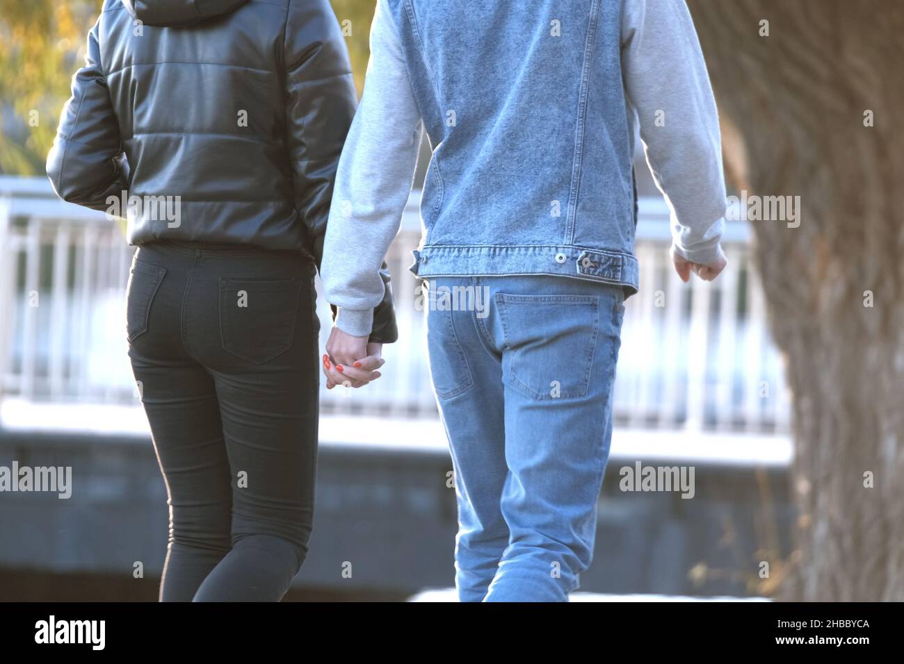 Back view of young couple walking on city street enjoying time together ...