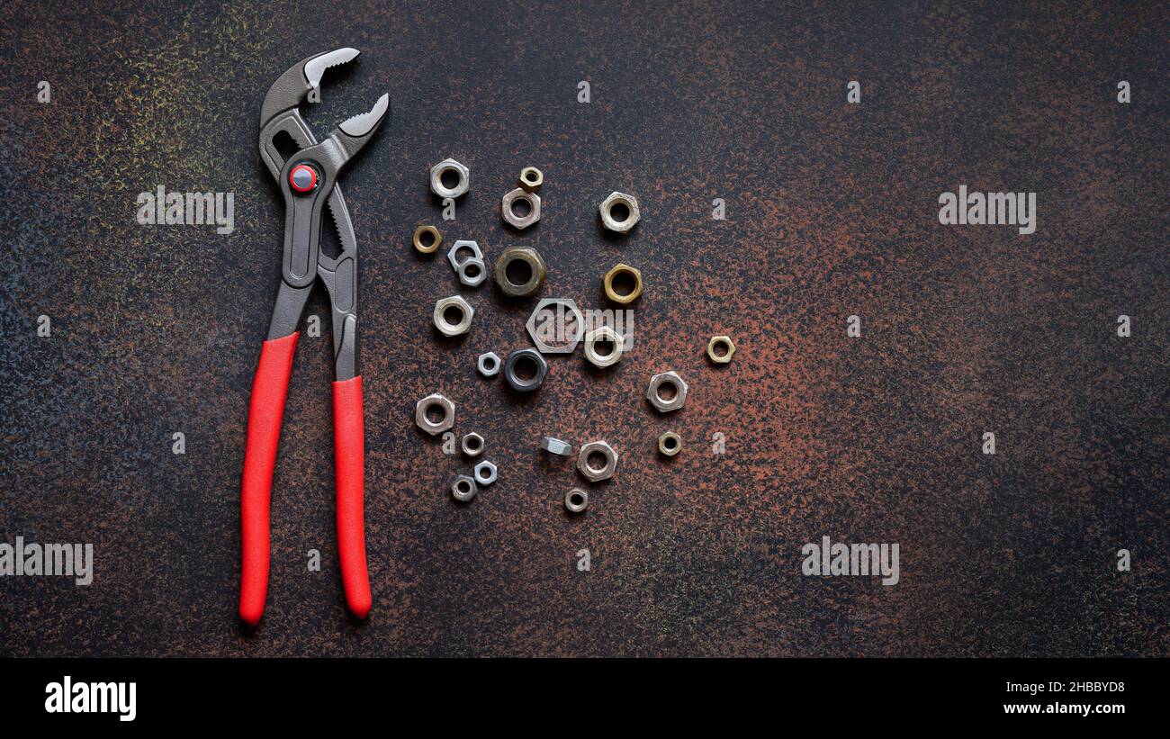 Top view of adjustable universal pliers for repair and assorted nuts on ...