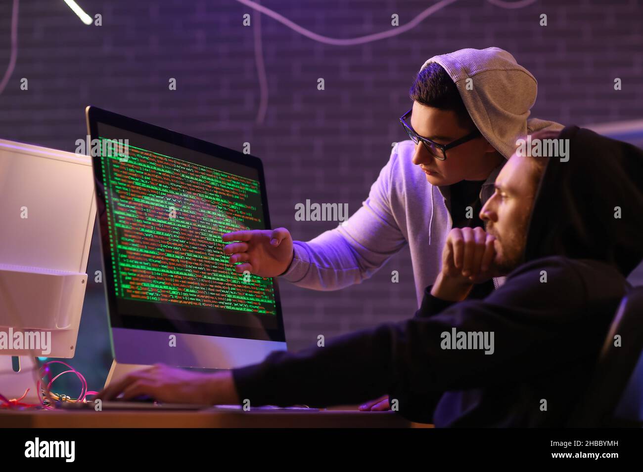 Hackers using computer in dark room Stock Photo - Alamy