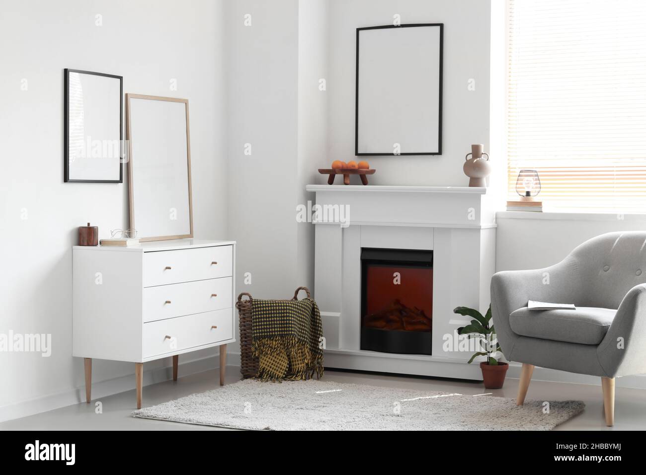 Living room with fireplace and blank posters Stock Photo - Alamy