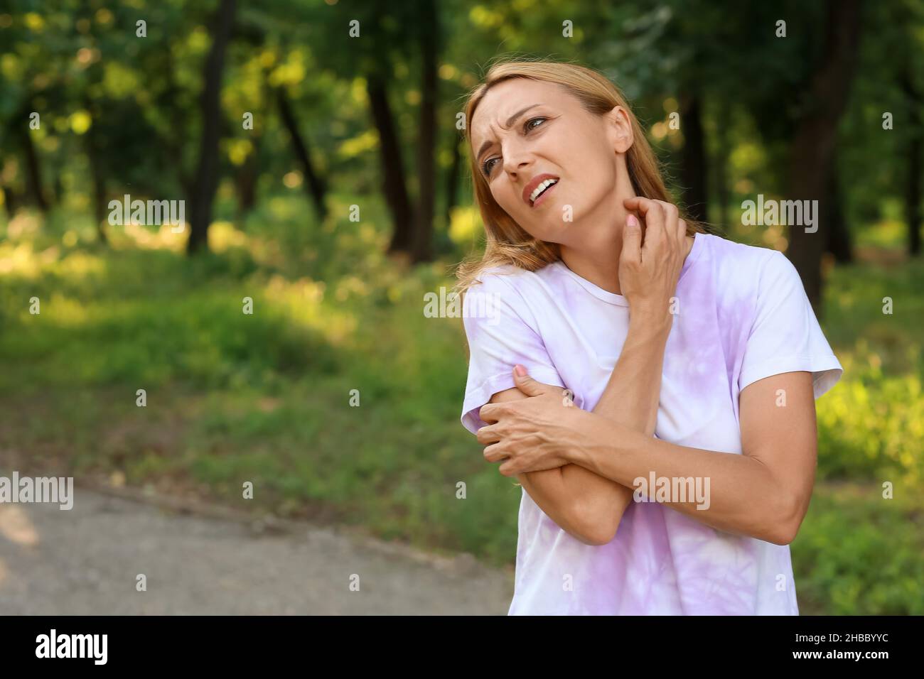 Mature woman scratching herself outdoors Stock Photo - Alamy