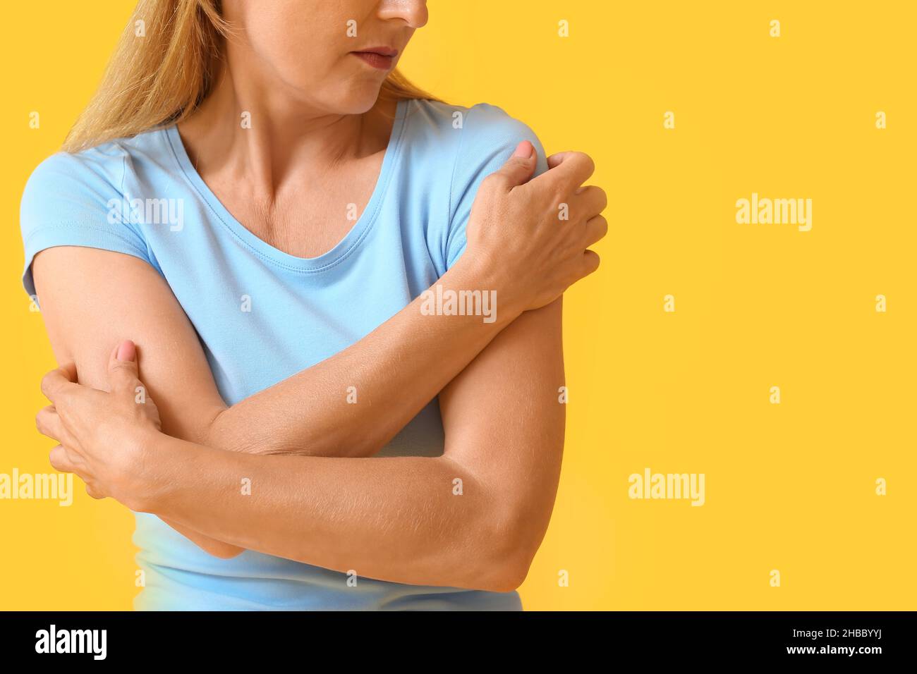 Mature woman scratching herself on color background Stock Photo - Alamy