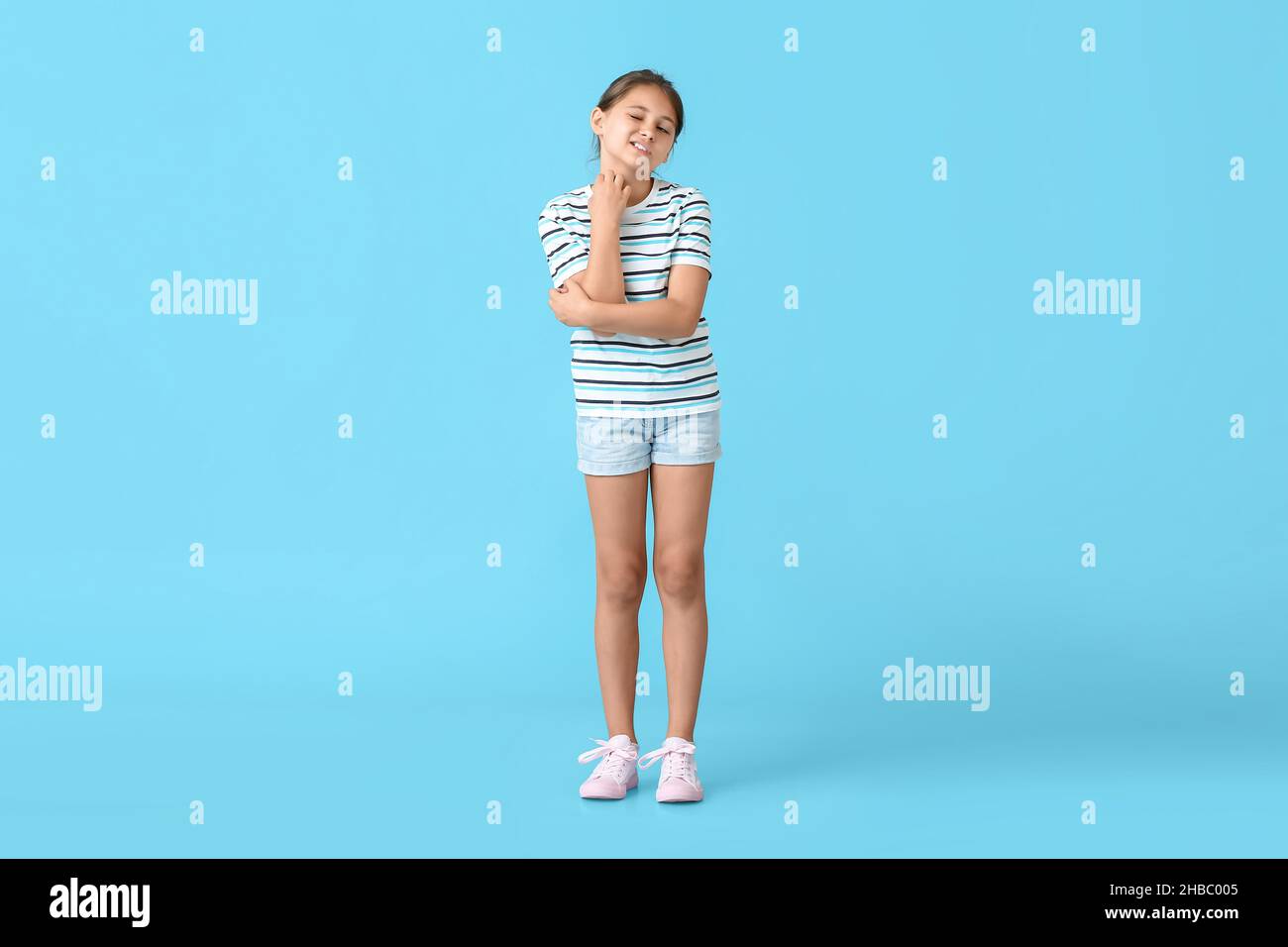 Little girl scratching herself on color background Stock Photo - Alamy