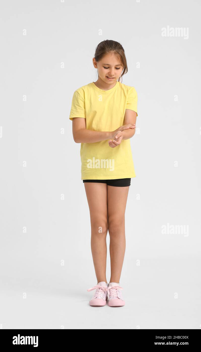 Little girl scratching herself on light background Stock Photo - Alamy