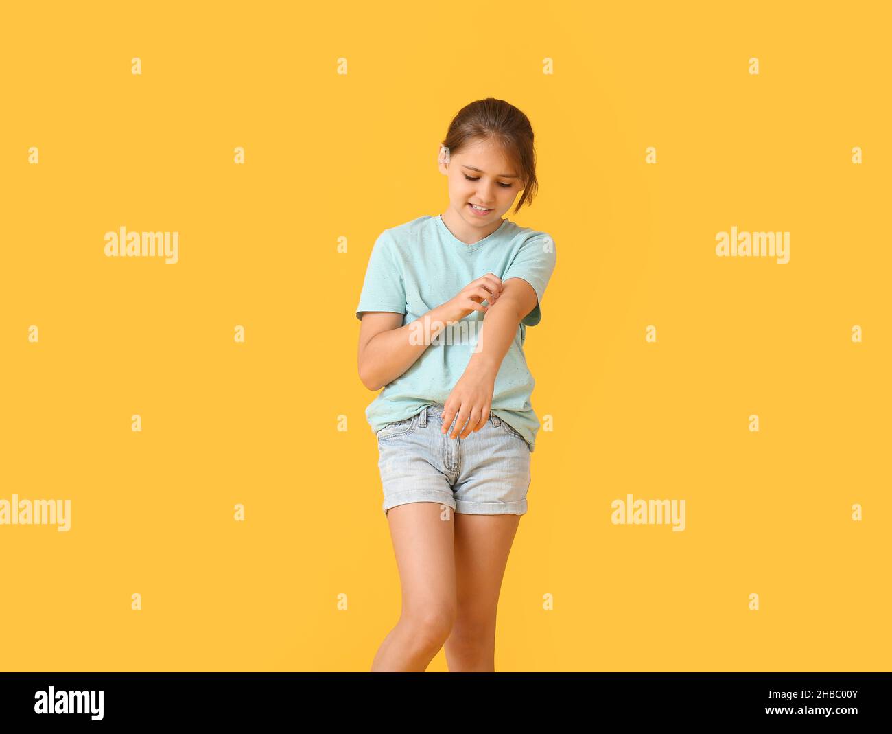 Little girl scratching herself on color background Stock Photo - Alamy