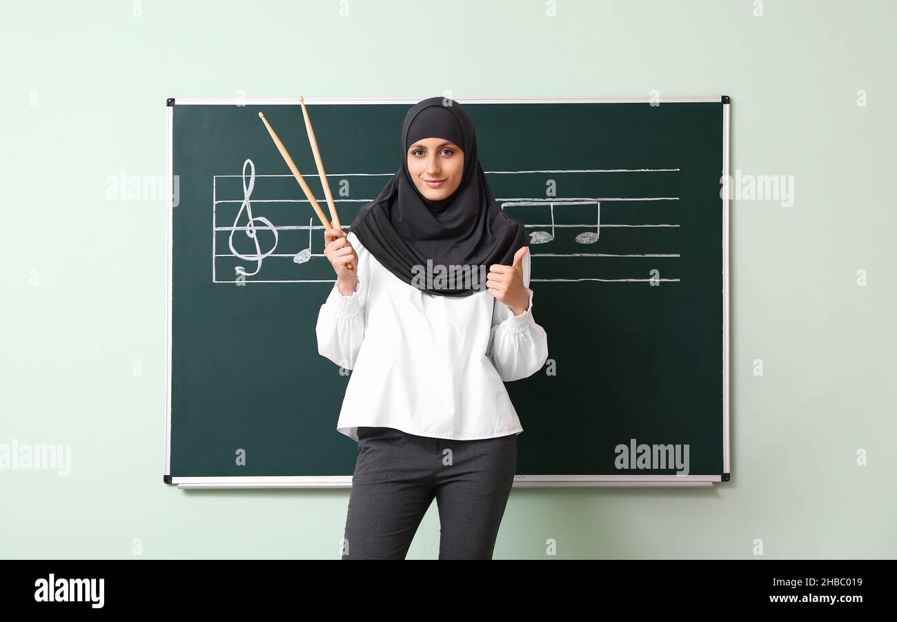 Muslim music teacher giving lesson at school Stock Photo - Alamy