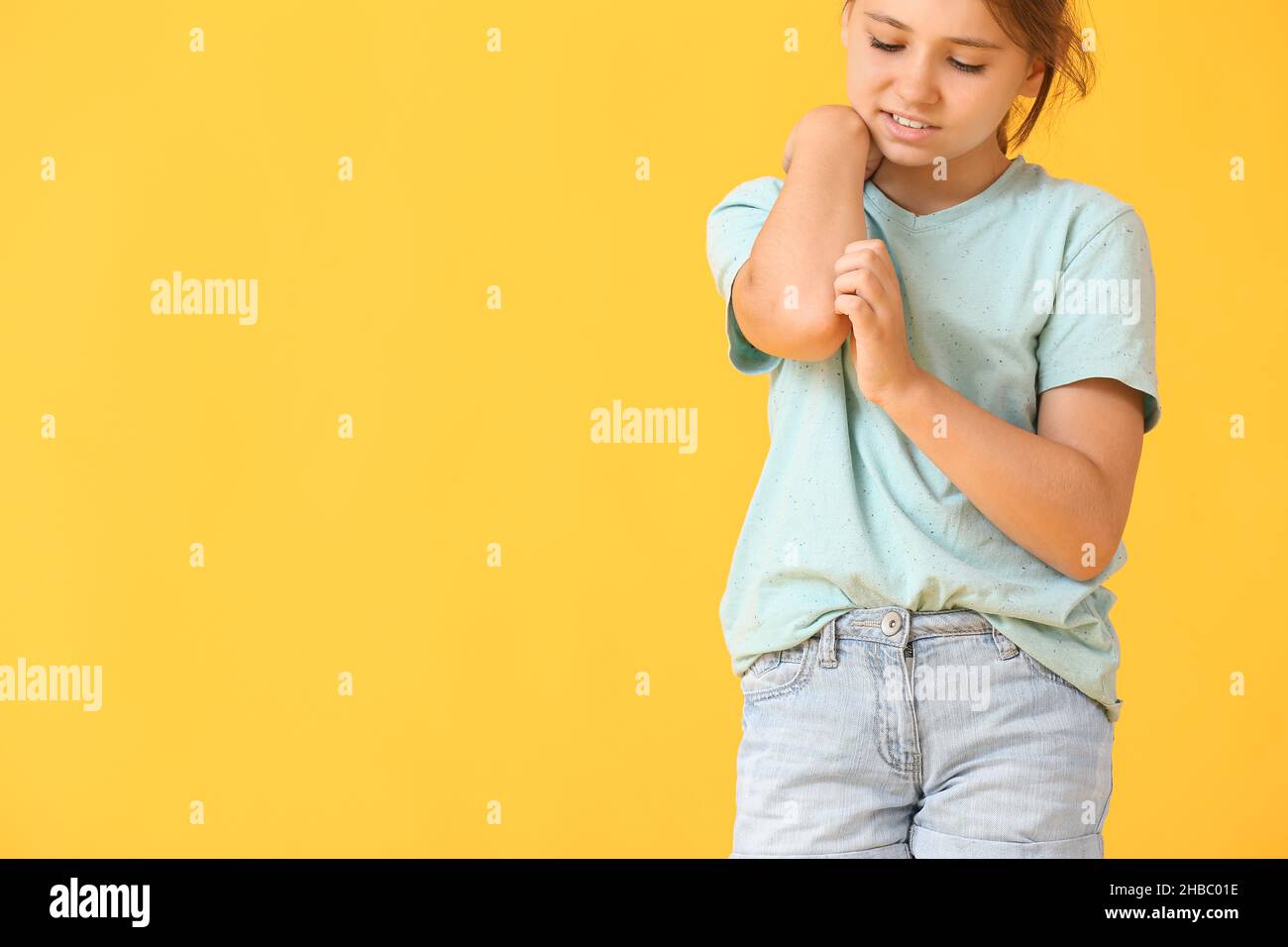 Little girl scratching herself on color background Stock Photo - Alamy