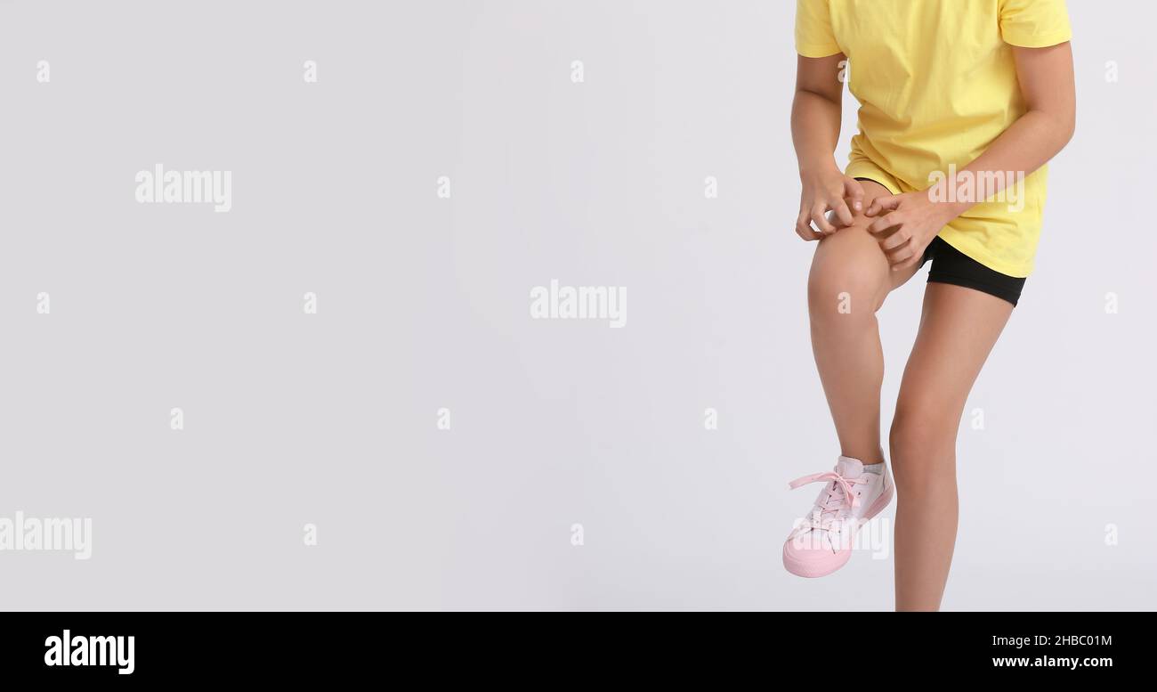 Little girl scratching herself on light background Stock Photo - Alamy