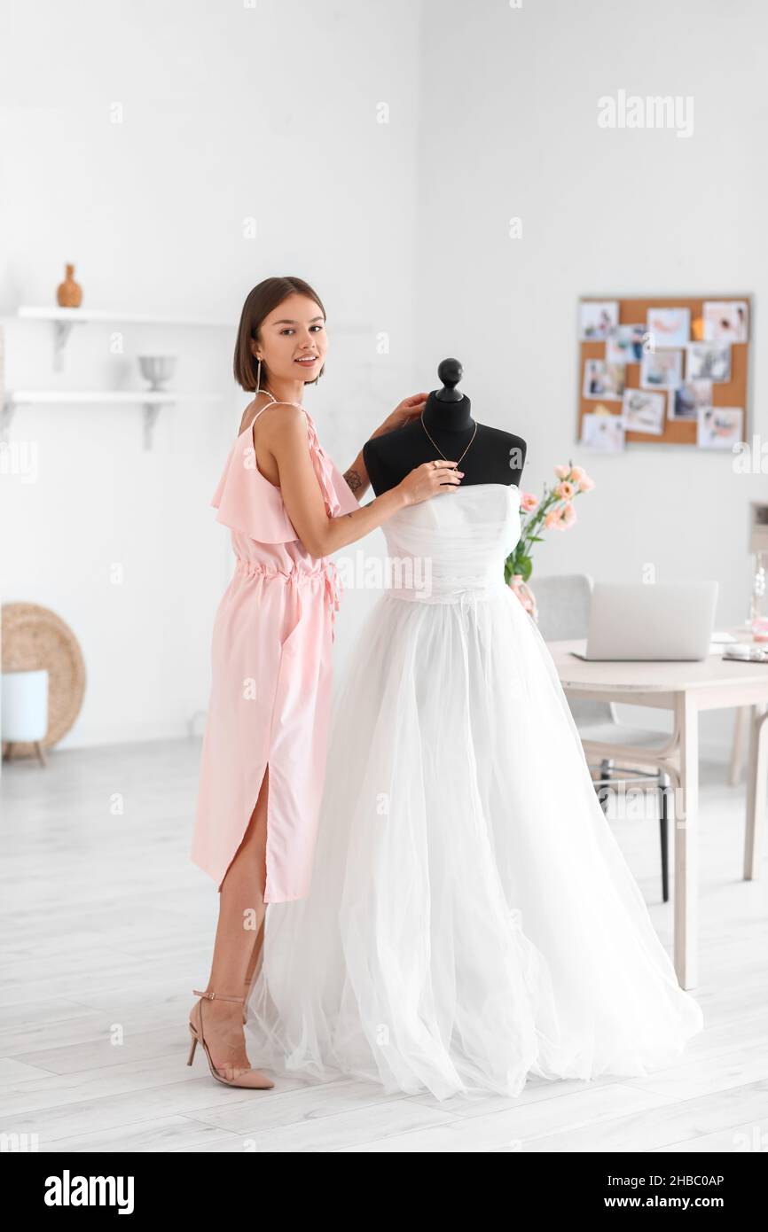 Female wedding planner with dress in office Stock Photo - Alamy