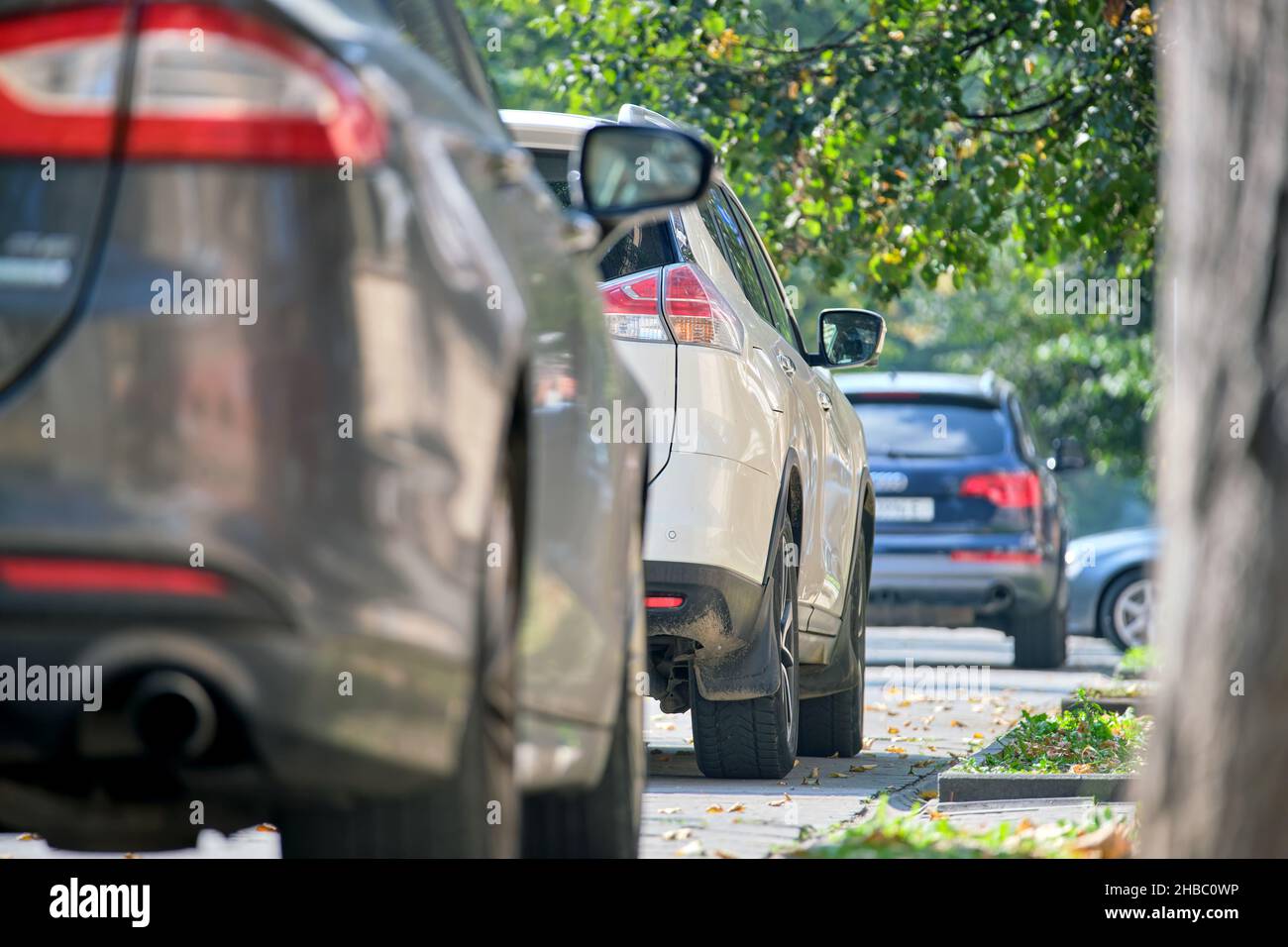 City traffic with cars parked in line on street side Stock Photo - Alamy