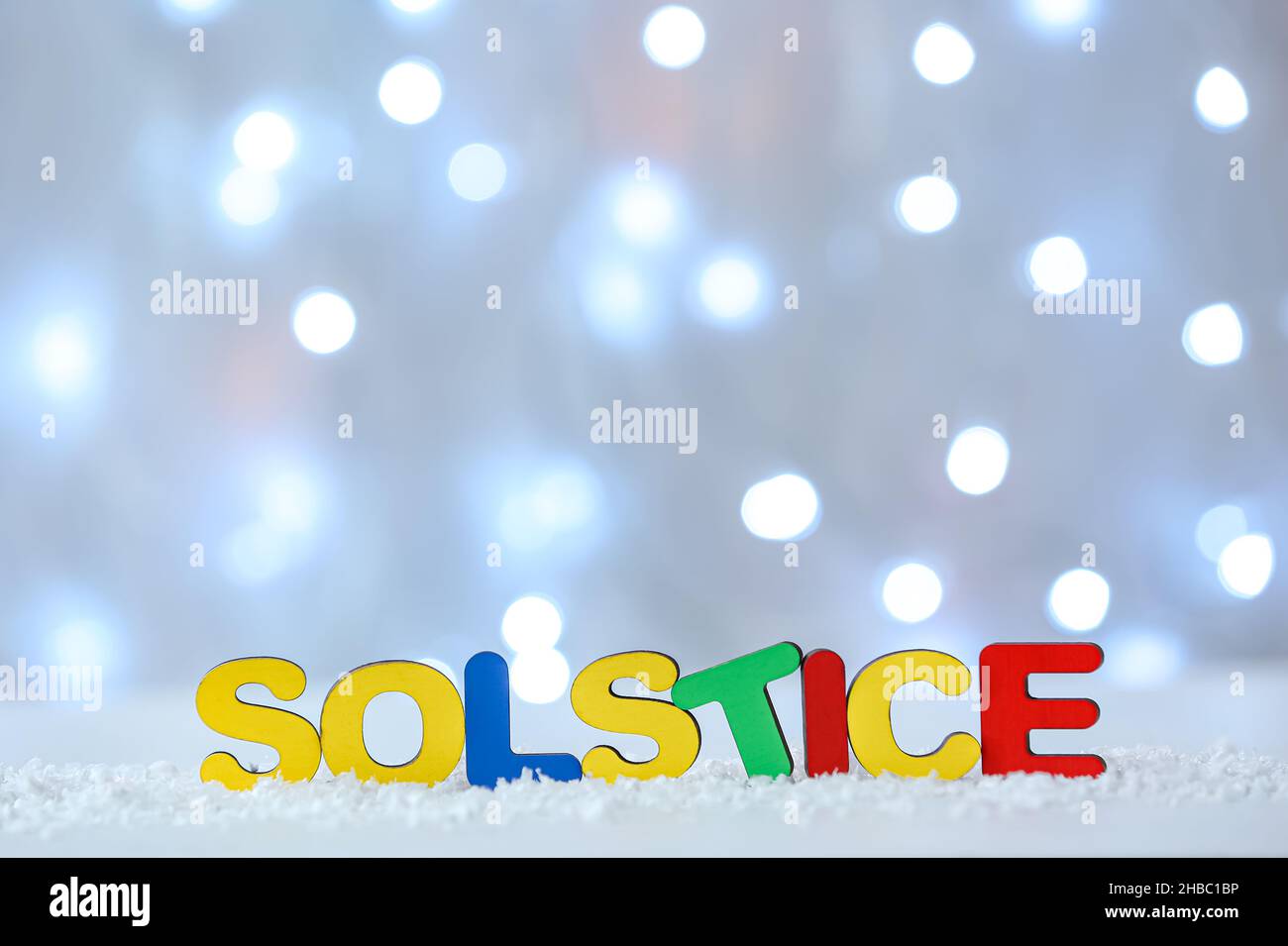 Word SOLSTICE and snow on light background with blurred lights Stock ...