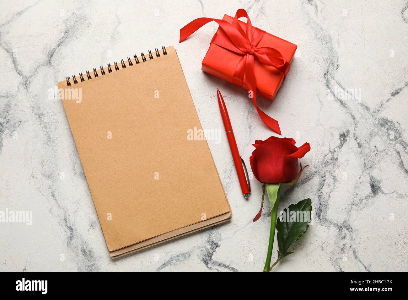 Empty notebook with gift and rose flower on white background Stock ...