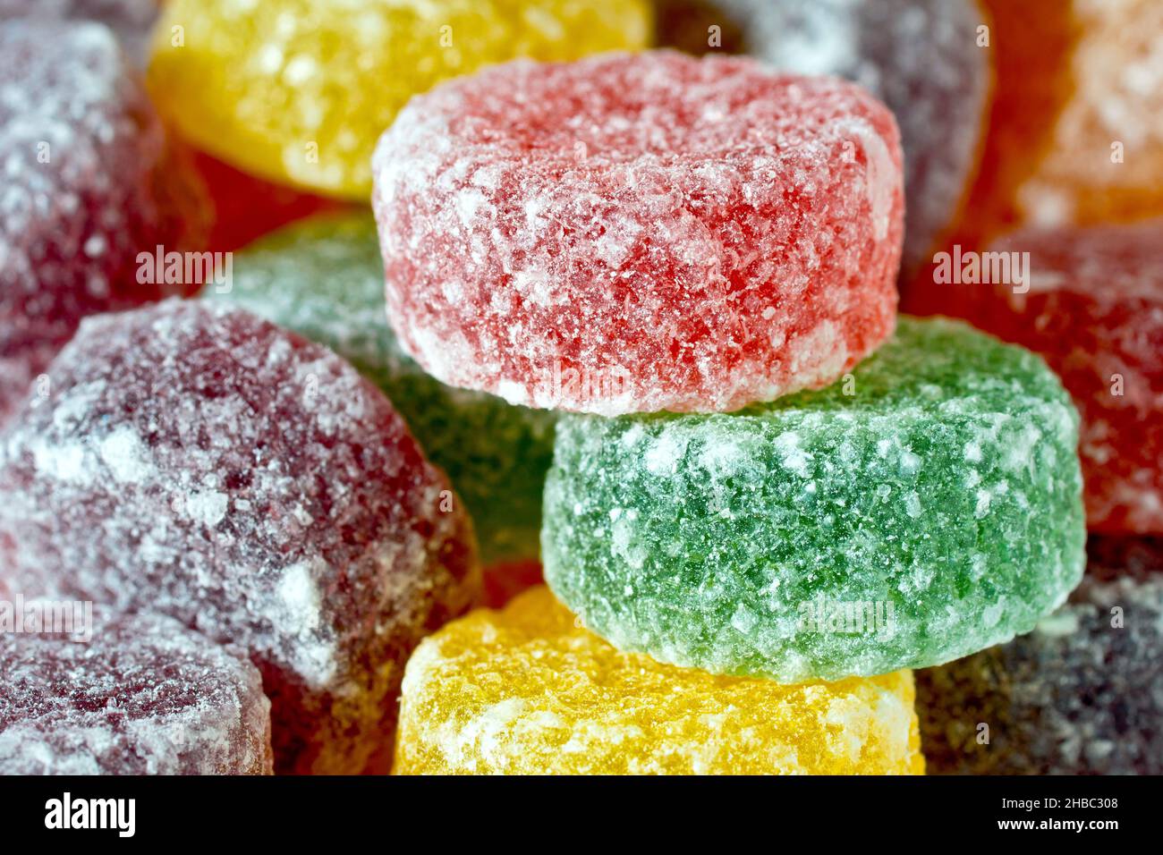 A close up of an off-centre stack of round, colourful, fruit flavoured ...