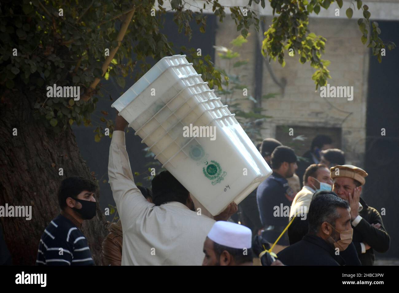 Peshawar, Pakistan. 18th Dec, 2021. A presiding officer carries a ...