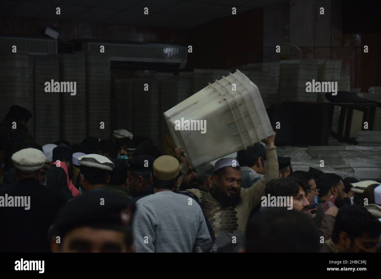 Peshawar, Pakistan. 18th Dec, 2021. A presiding officer carries a ...