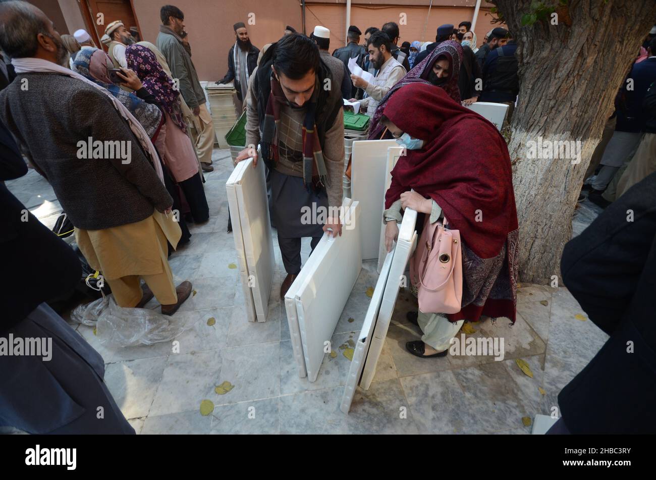 Peshawar, Pakistan. 18th Dec, 2021. A presiding officer carries a ...