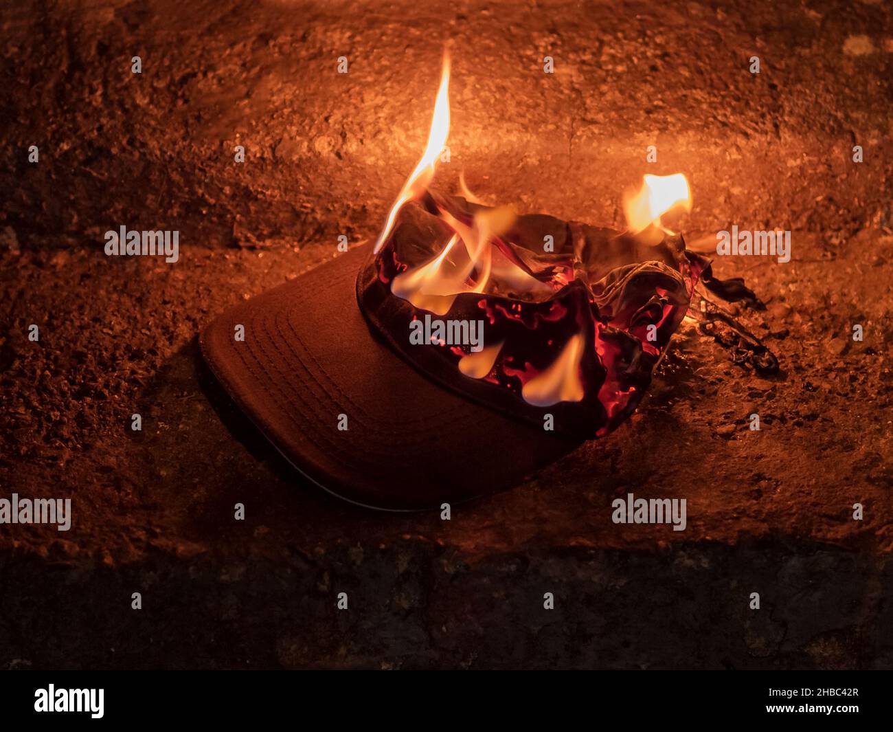 The textile cap burns with bright fire lying on the concrete steps in ...