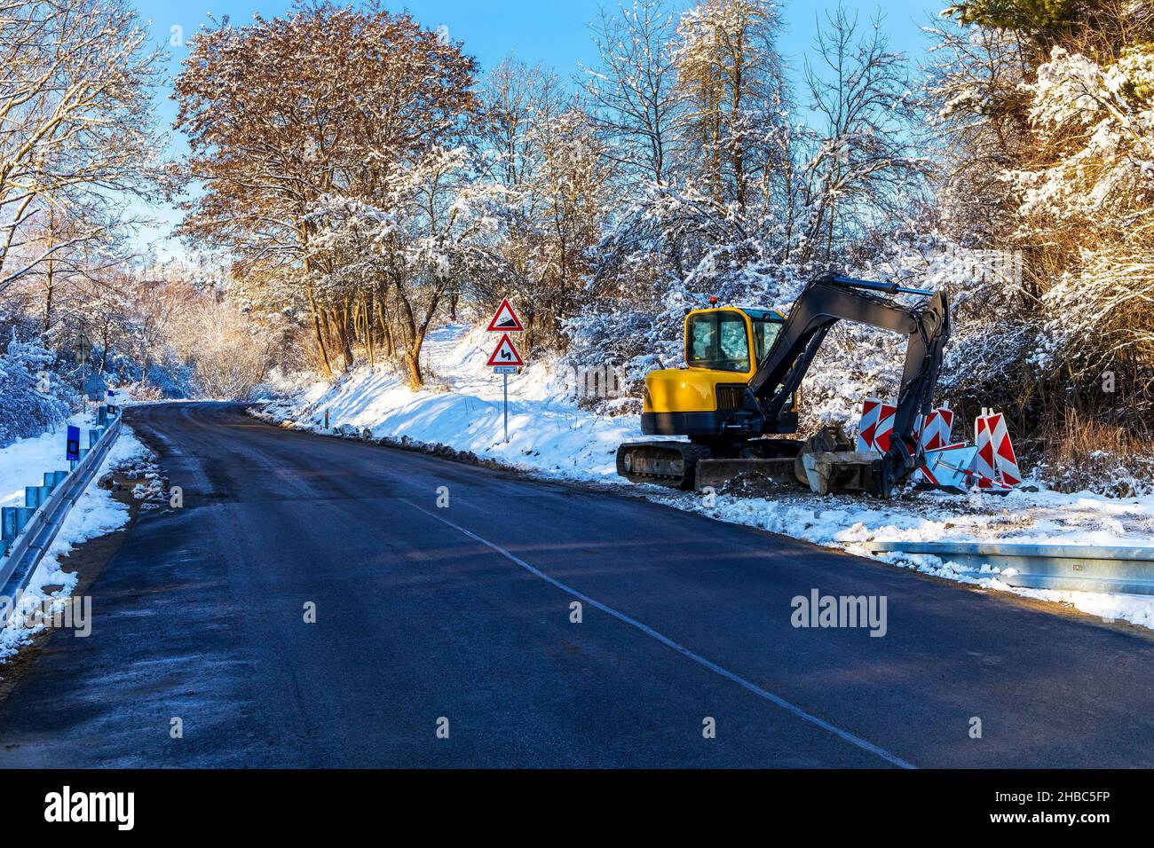 Excavator works in winter to repair the road. Excavator On Earthworks ...