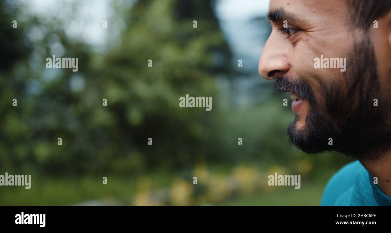Portrait of a cheerful adult Indian man having a conversation in a ...