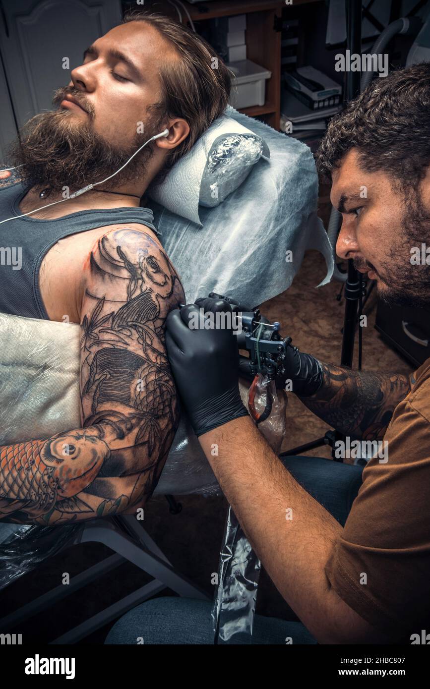 Professional tattooist at work in studio Stock Photo - Alamy