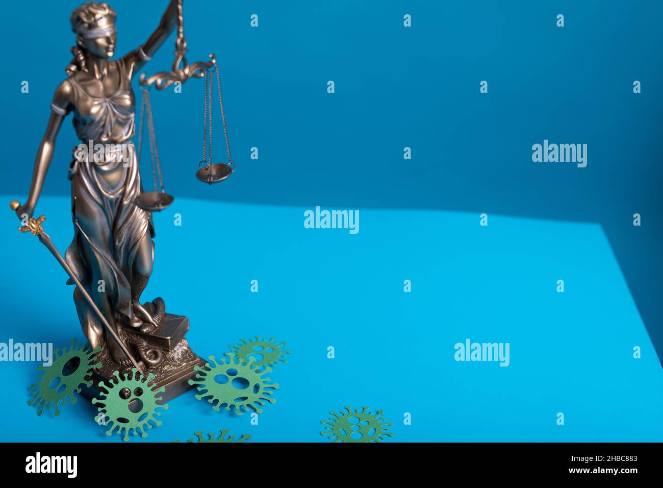 Sculpture of Themis the Greek goddess of justice with green virus ...