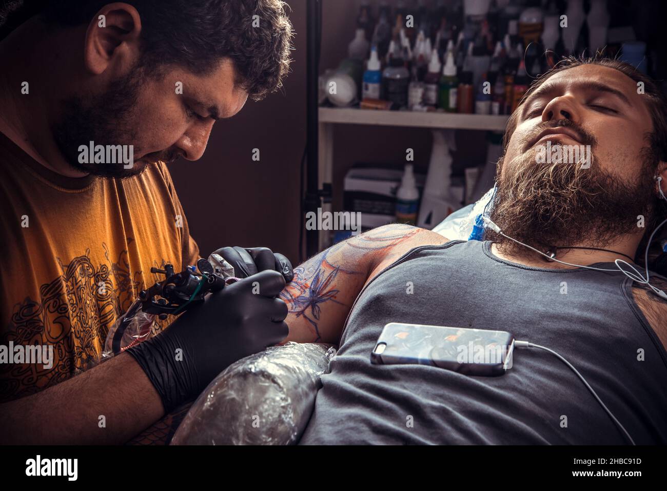 Master doing tattoo in studio Stock Photo - Alamy