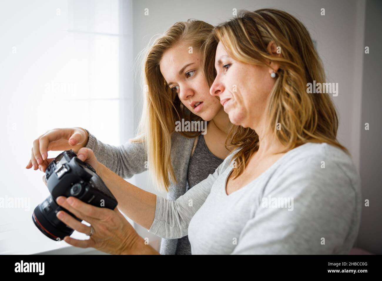 Mother and daughter taking photos and checking them on a modern digital ...